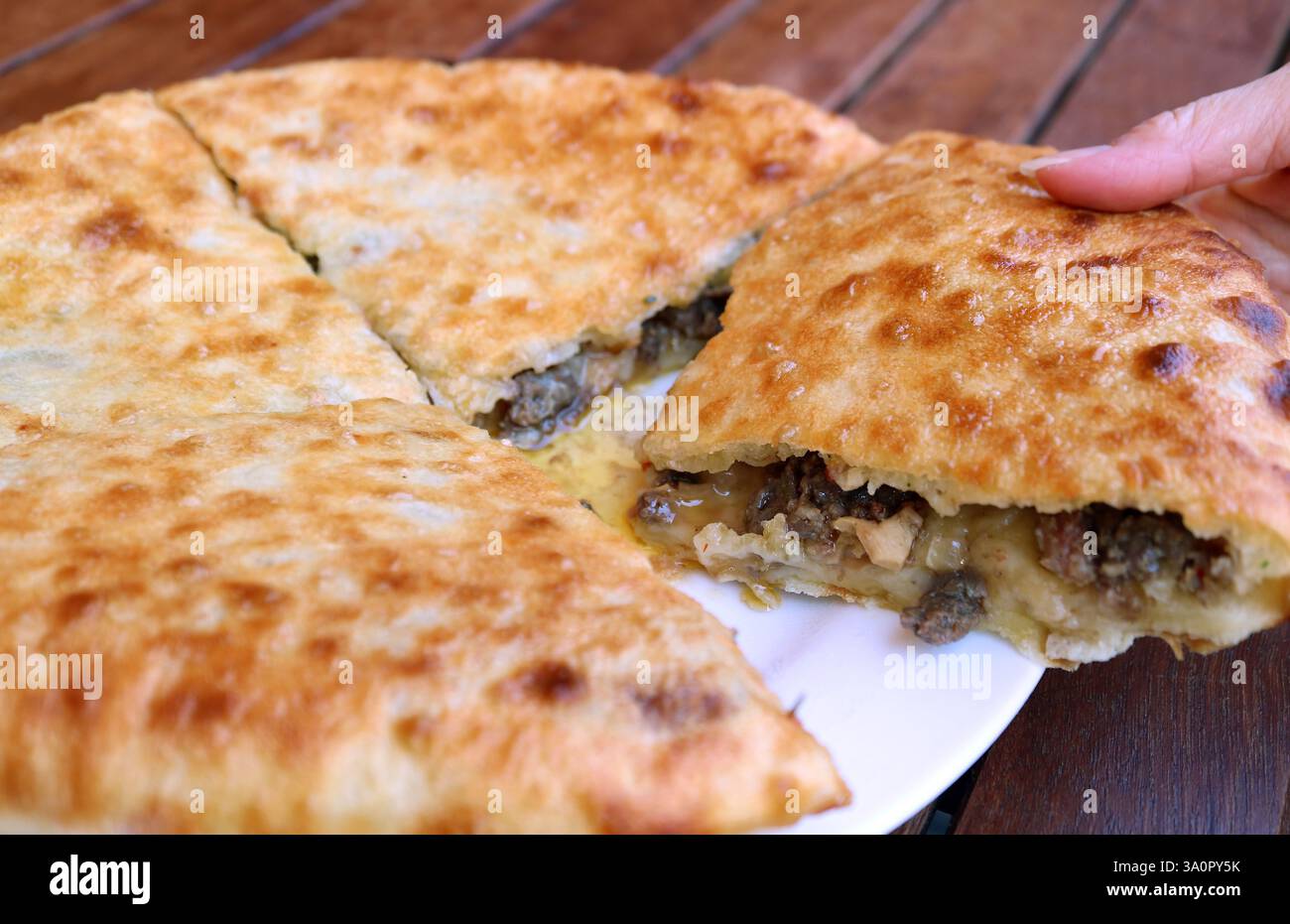 Hand Picking Up a Sliced of Kubdari, Tasty Georgian Flat Bread Stuffed ...