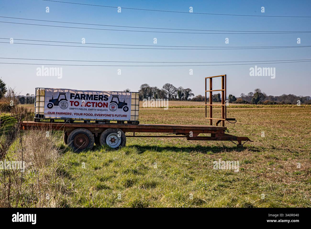 FARMERS TO ACTION banner attached to water carriers on a farm trailer ...
