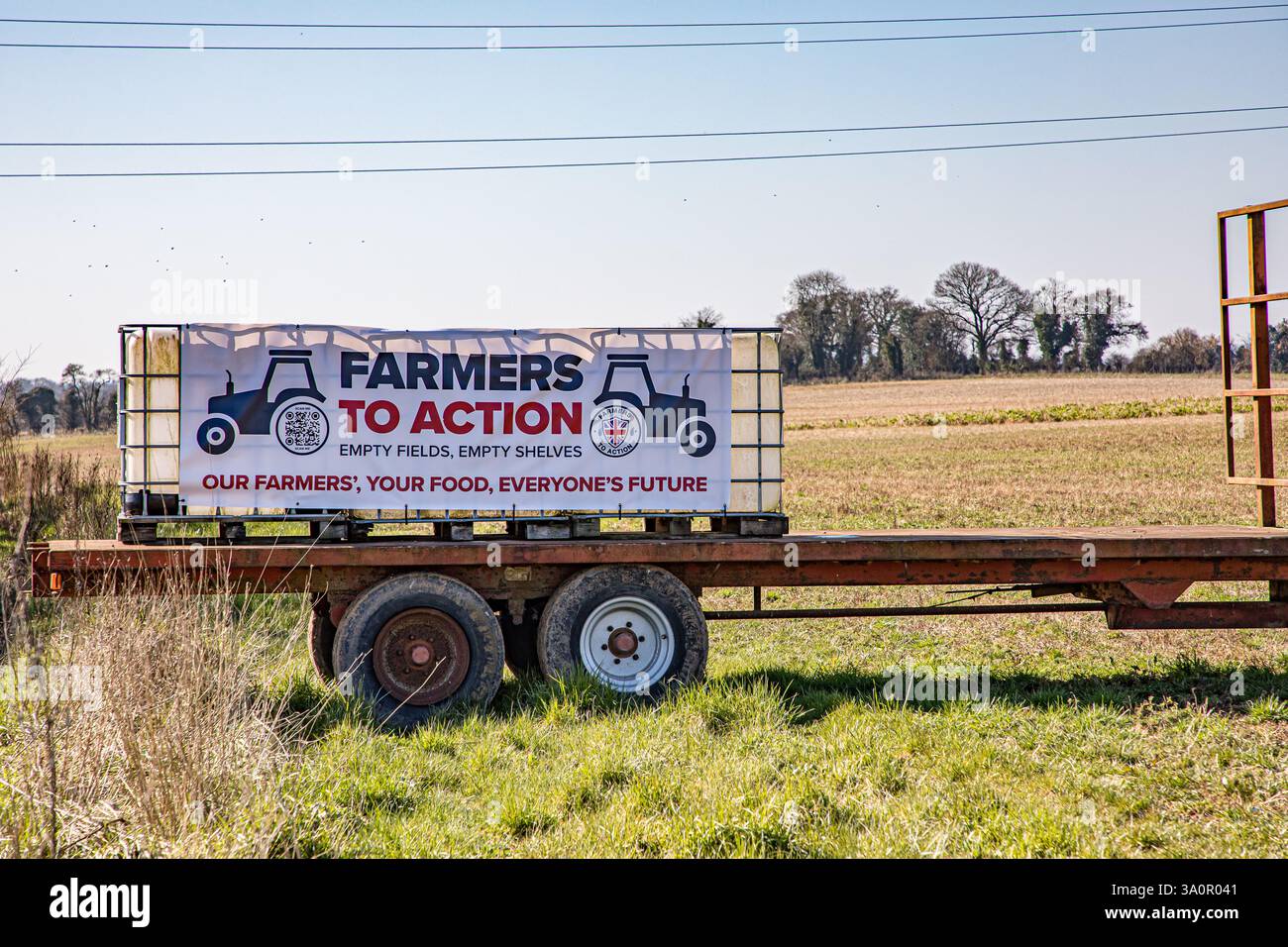 FARMERS TO ACTION banner attached to water carriers on a farm trailer ...
