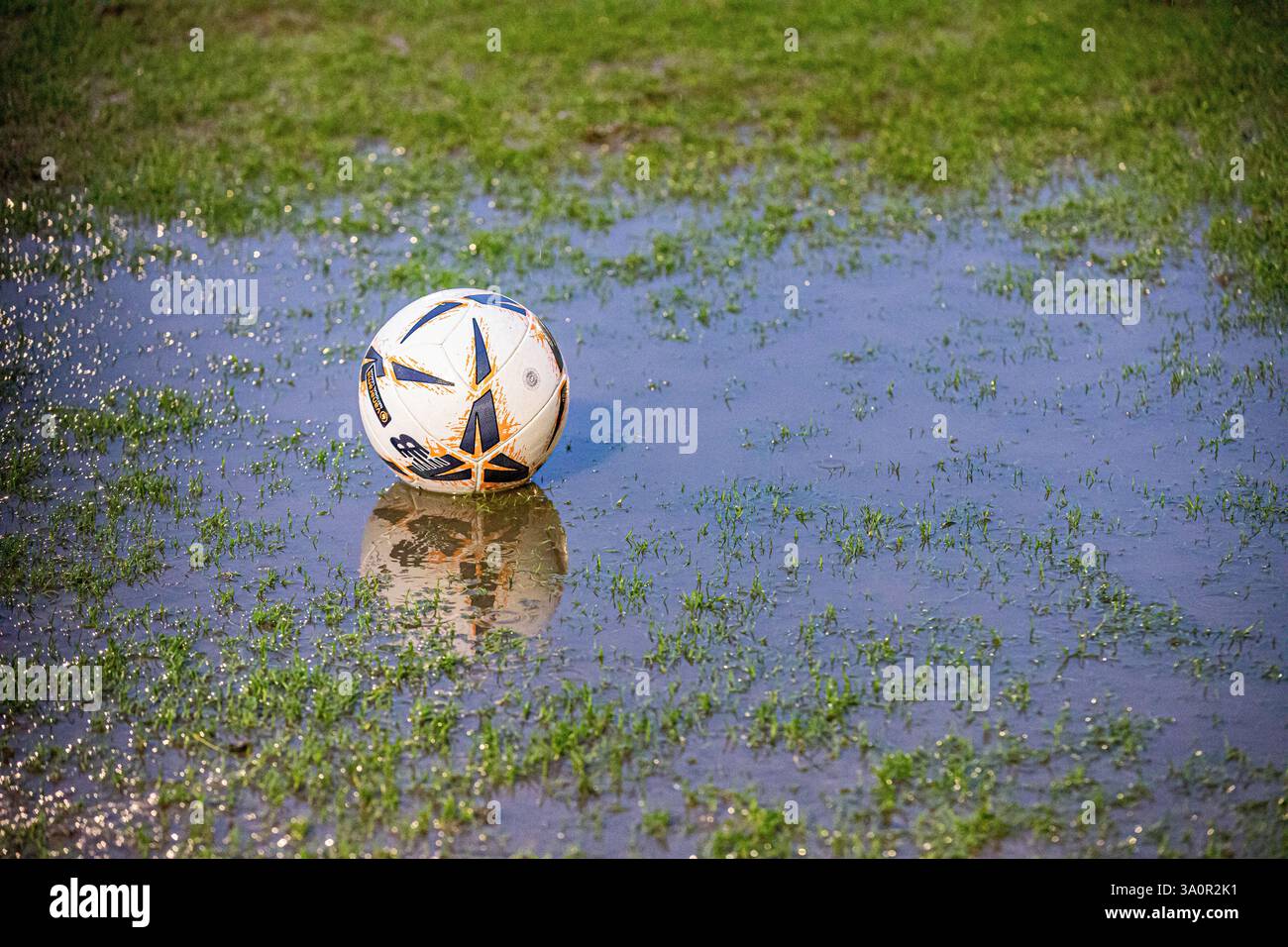 Vanarama National League football in a puddle on a flooded football ...