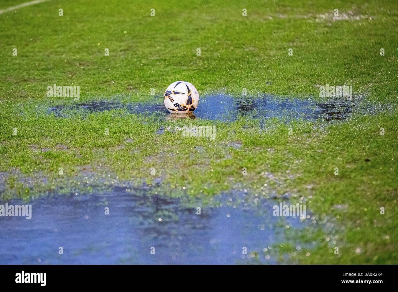 Vanarama National League football in a puddle on a flooded football ...