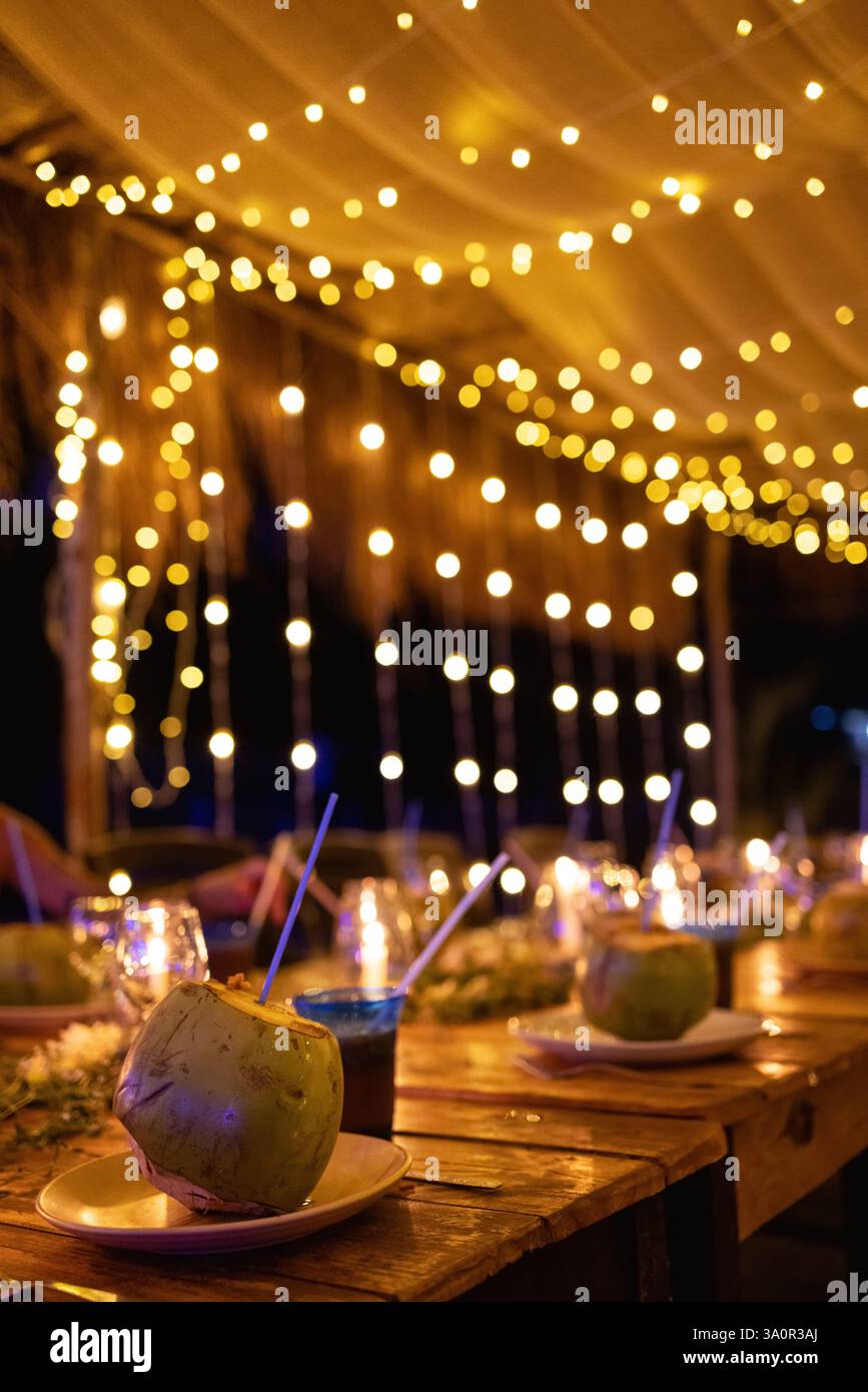 Outdoor dinner table at night with coconuts Stock Photo - Alamy