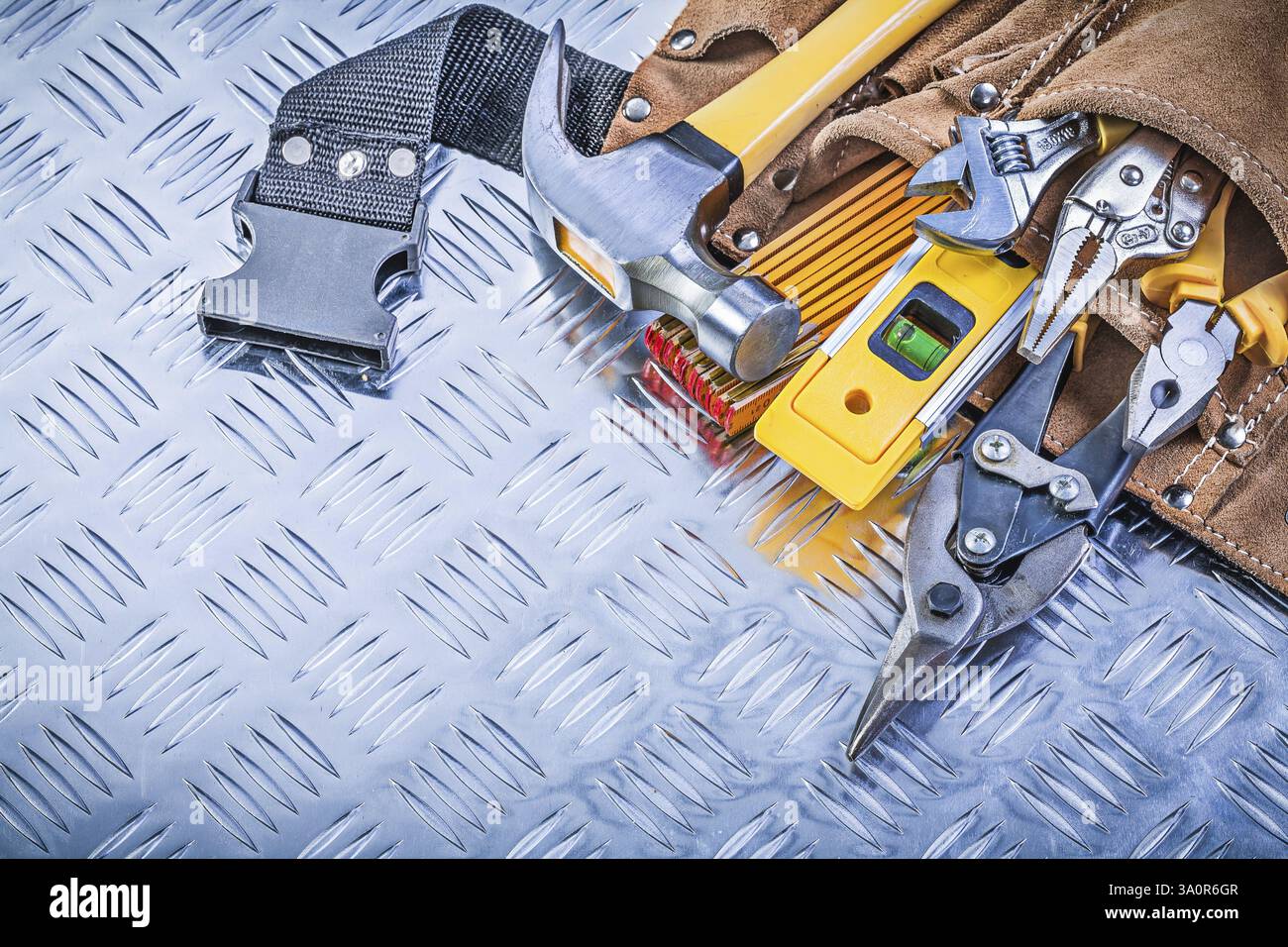 Collection of construction tooling in tool belt on corrugated metal ...