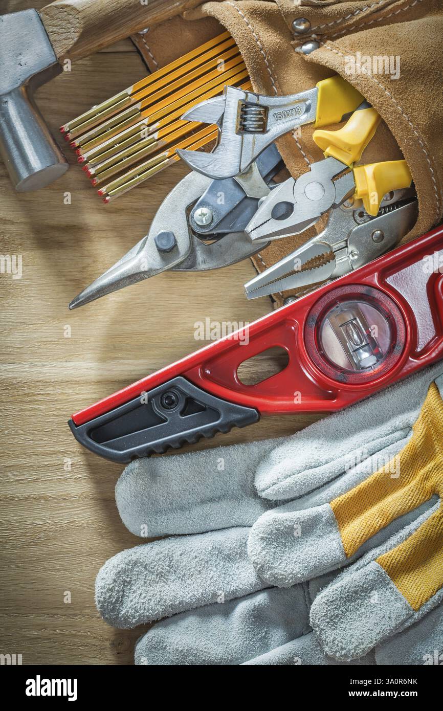 Composition of construction tooling in leather tool belt on wooden ...