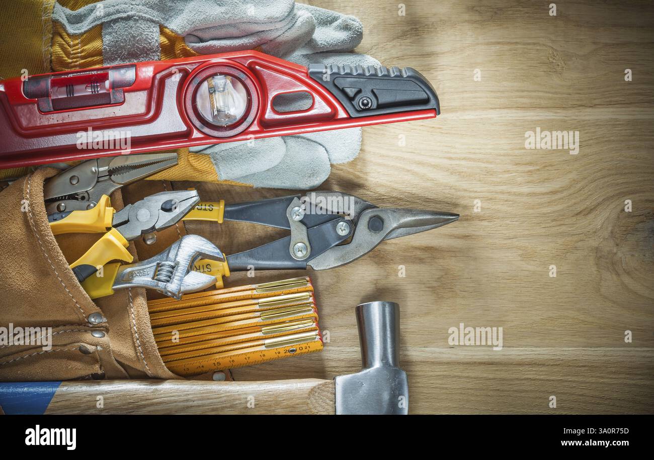 Collection of construction tooling in building belt on wood board Stock ...