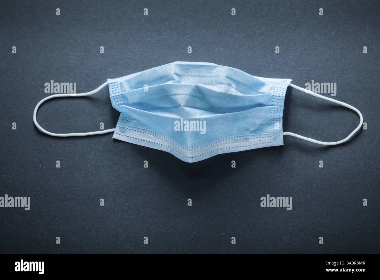Disposable surgical mask on black background Stock Photo - Alamy