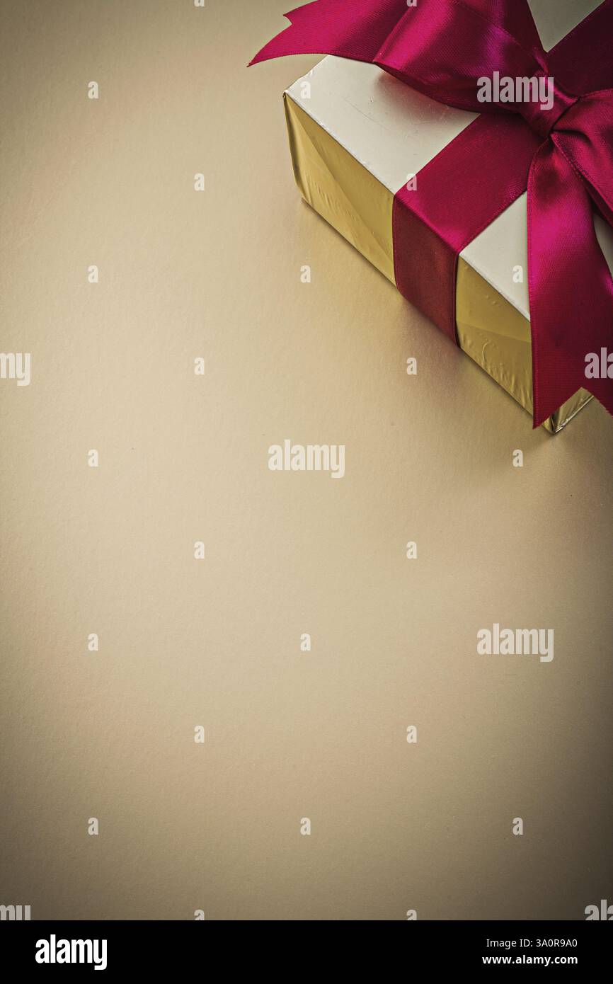 Boxed gift with tied bow on golden background holidays concept Stock ...