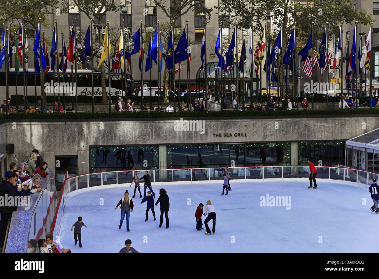 Rockefeller Center, people on a skating rink in an urban scene with ...