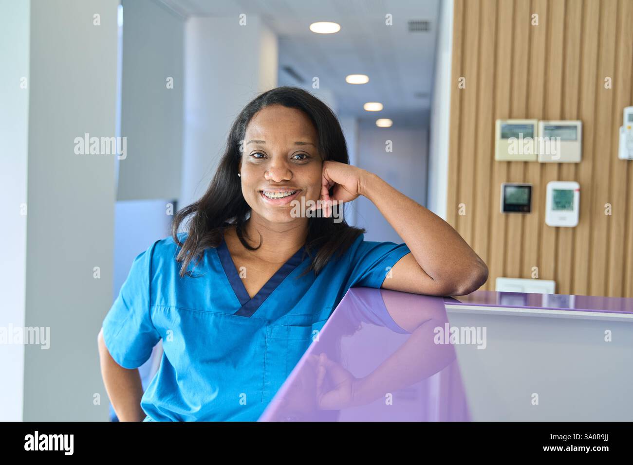 Portrait of a confident and friendly dentist smiling while leaning on ...