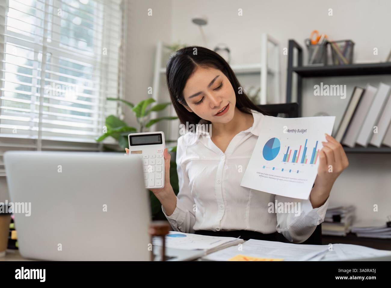 Budgeting and financial management. A businesswoman calculating monthly ...