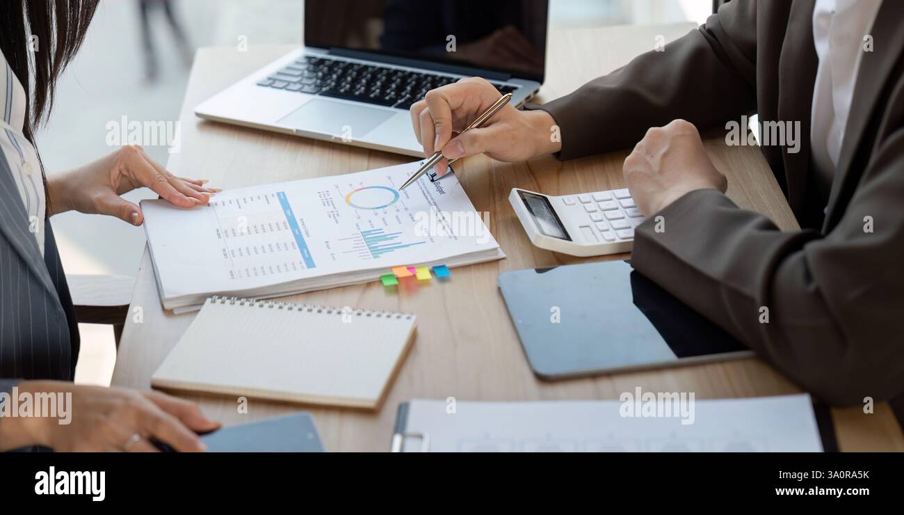 Data analysis in progress. Professionals reviewing financial charts and ...