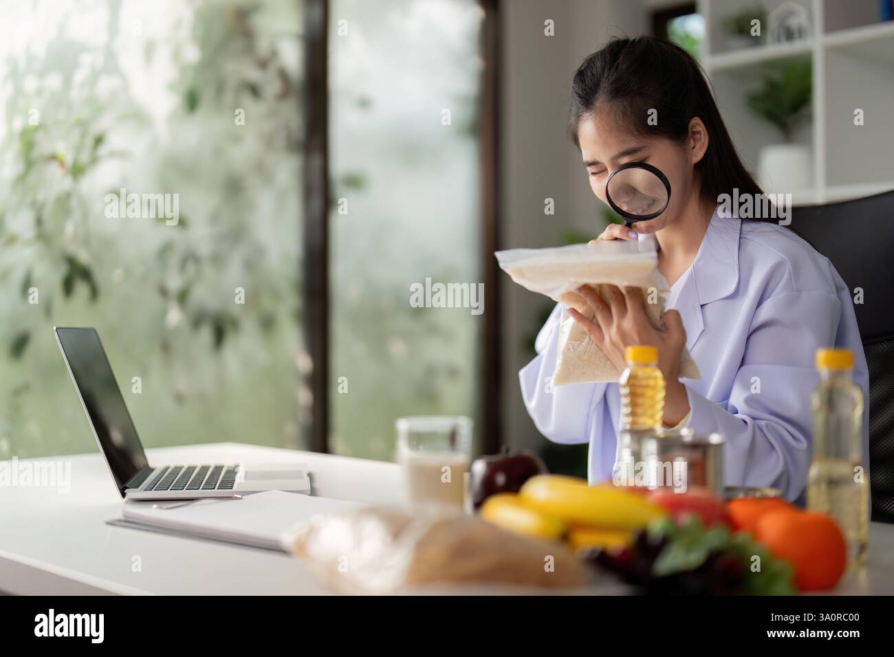 Food inspection. A nutritionist examining a packaged product closely ...