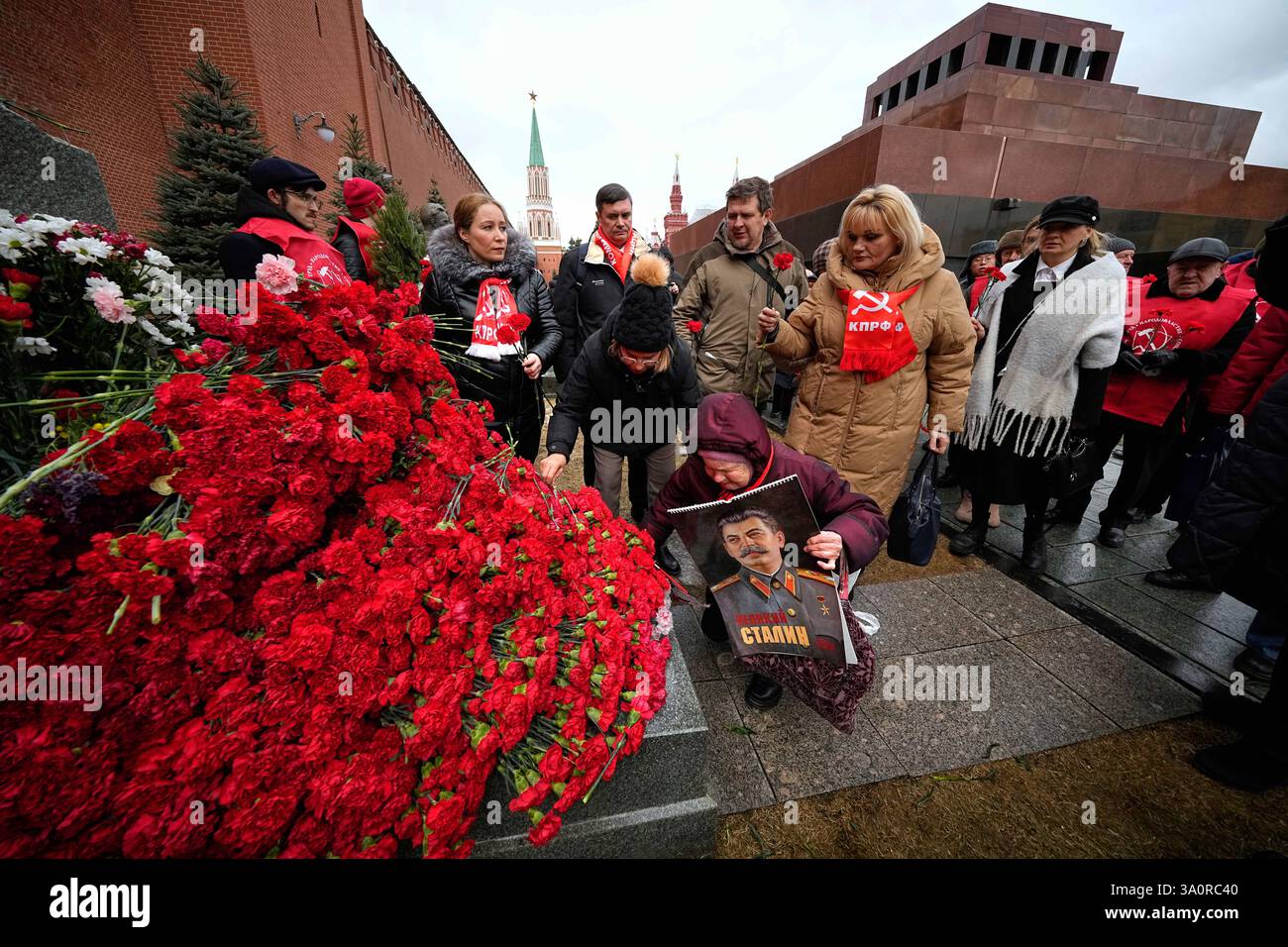 An elderly woman holds a portrait of Soviet leader Joseph Stalin lays ...