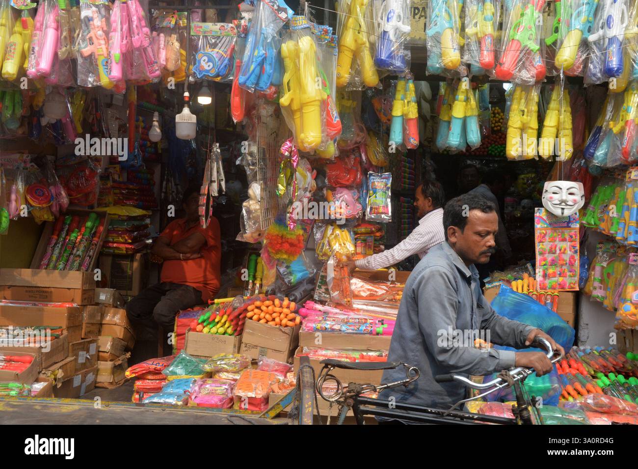 March 5, 2025, Siliguri, West Bengal, India: People buy holi decorative items at a market area ...