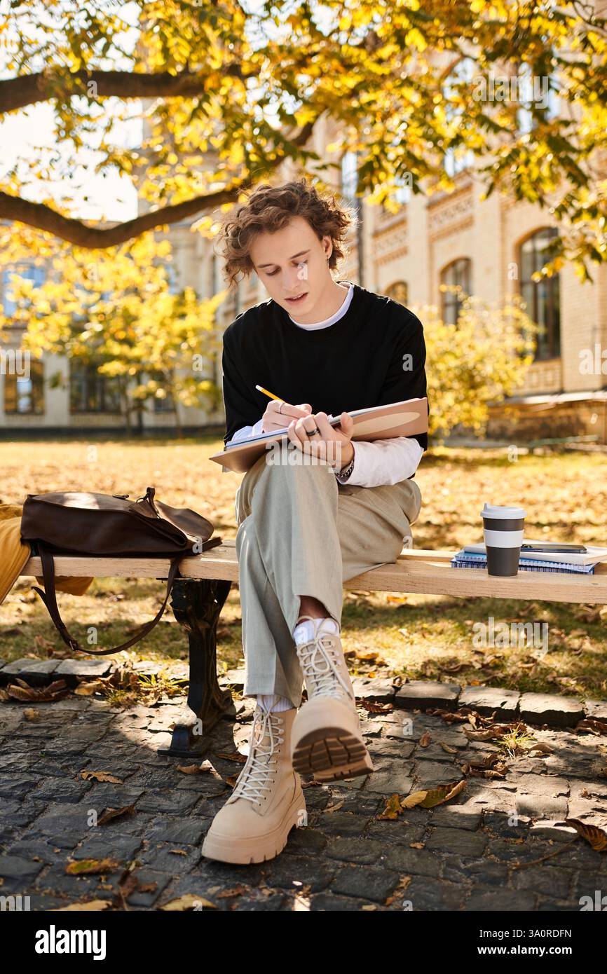 Handsome student engaged in note taking at a serene campus spot filled ...