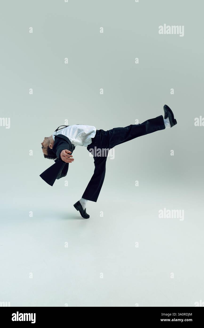 Young businessman balancing in dynamic pose with extended arms and ...