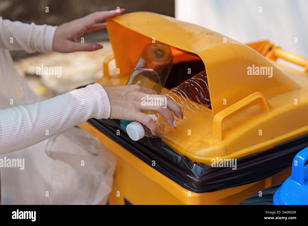 Innovative Recycling Practices. A volunteer responsibly discards plastic waste into designated ...