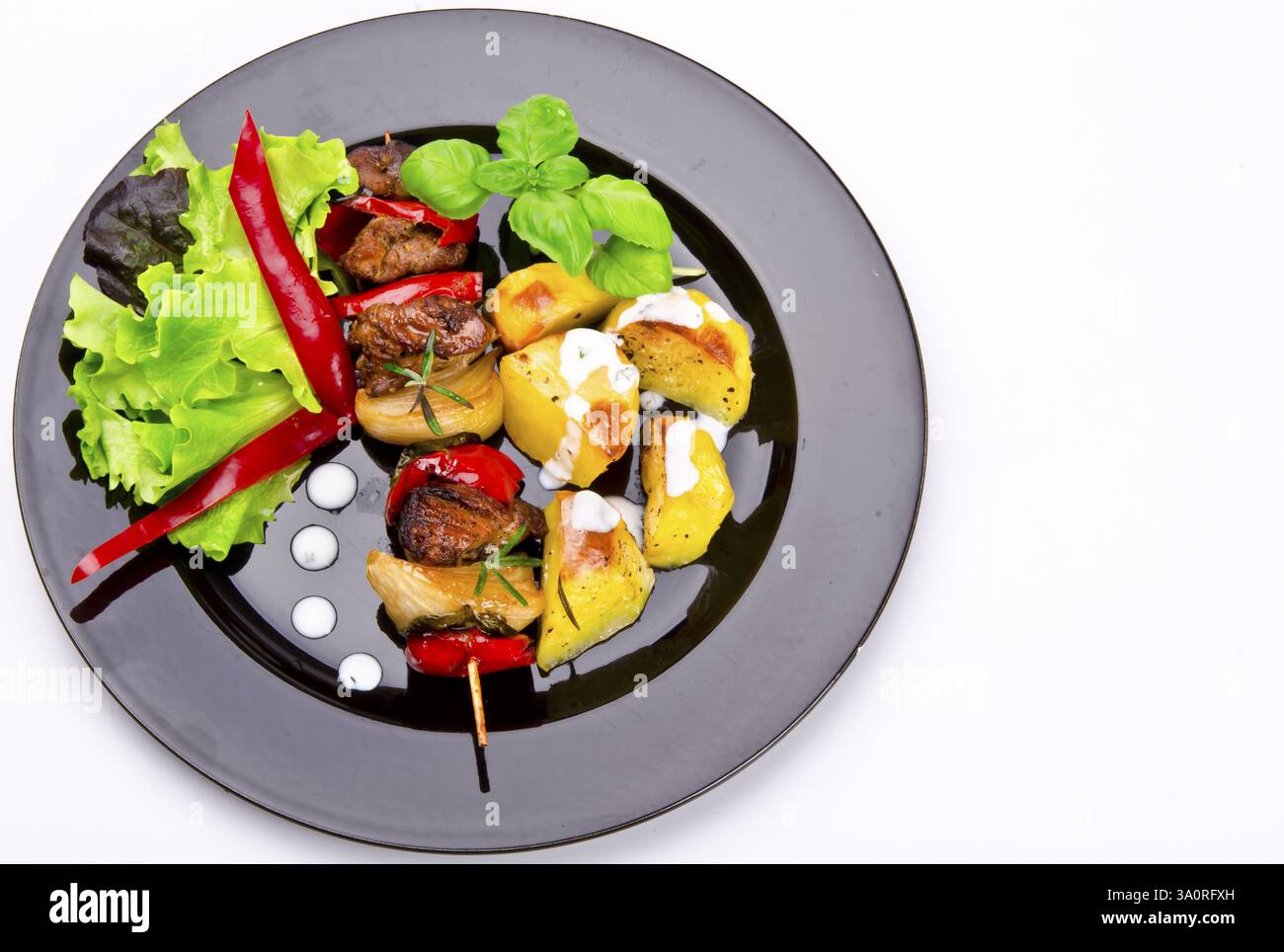 Meat spit with fried potatoes Stock Photo - Alamy