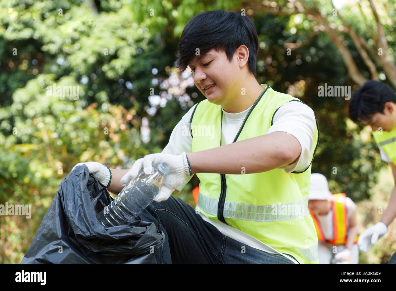 Sustainability in Action. A young volunteer collecting plastic waste ...