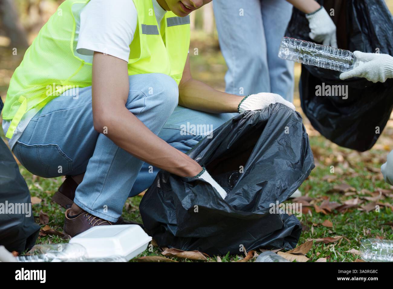Waste management. Volunteers sorting waste in an environmental cleanup ...