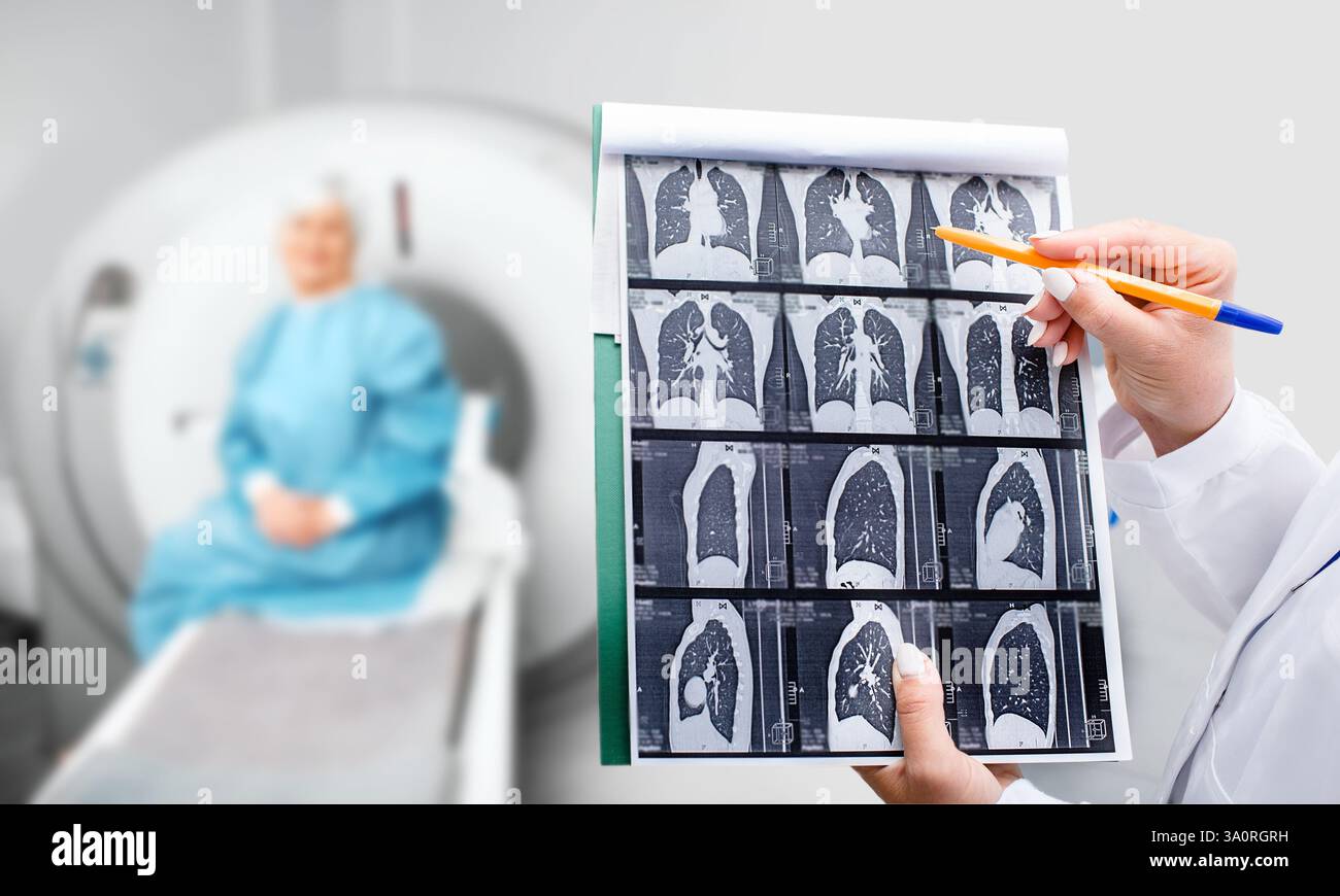 A healthcare worker examines CT scan images while seated patient awaits ...