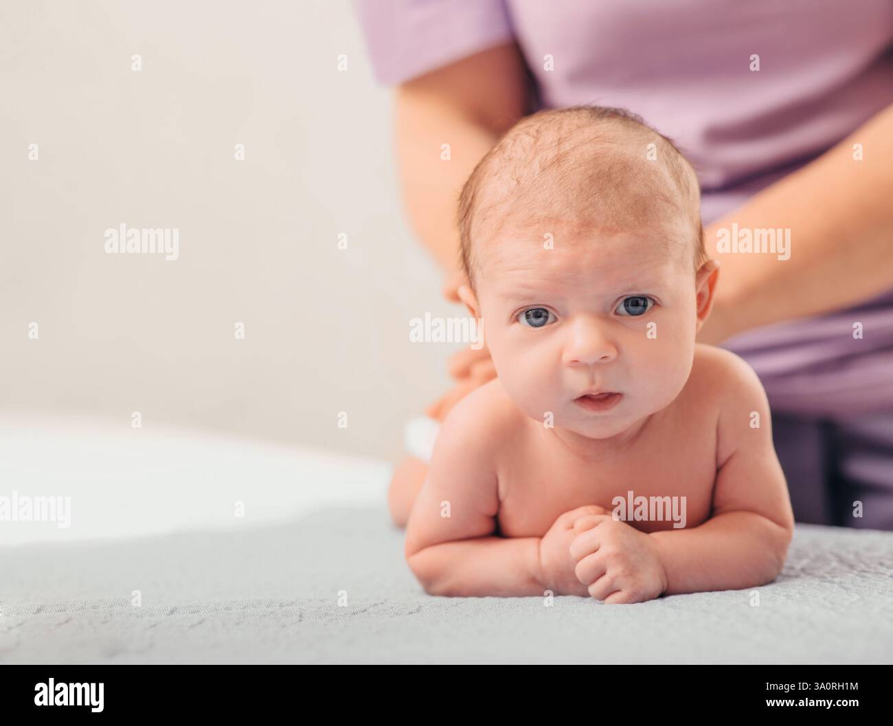 A healthcare provider cares for a newborn baby during a routine examination, ensuring the infant ...