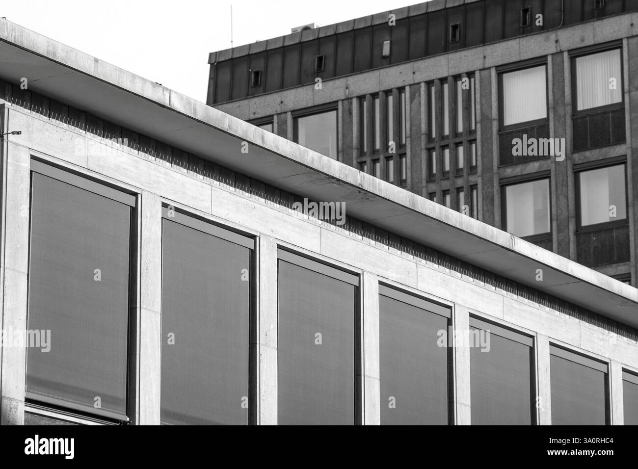 Modern concrete building facade with windows and overhanging roof, in ...