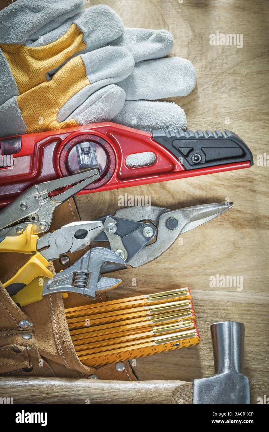 Collection of construction tooling in leather building belt on wooden ...