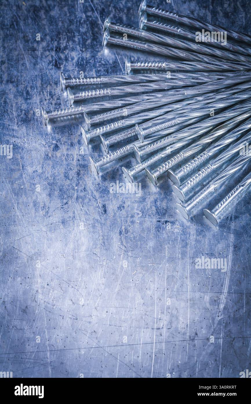 Collection of stainless construction nails on scratched metallic ...