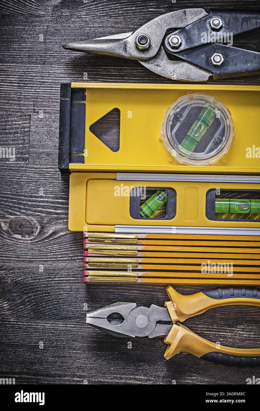 Construction level wooden meter pliers wire cutter on wooden surface ...