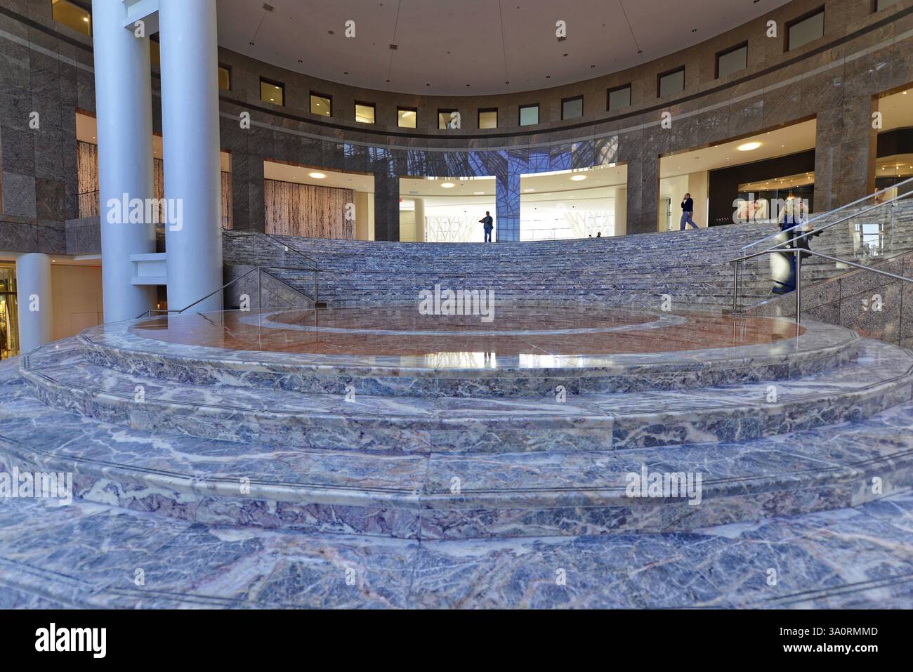 Modern stone stairs in a circular interior with exposed stone patterns ...