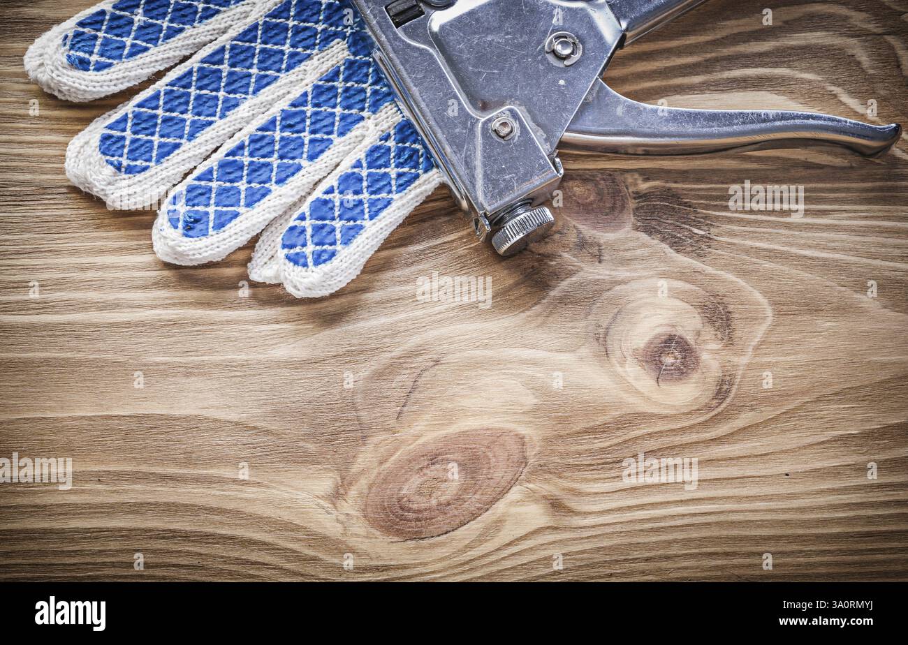 Composition of stapler gun safety gloves on wooden board Stock Photo ...