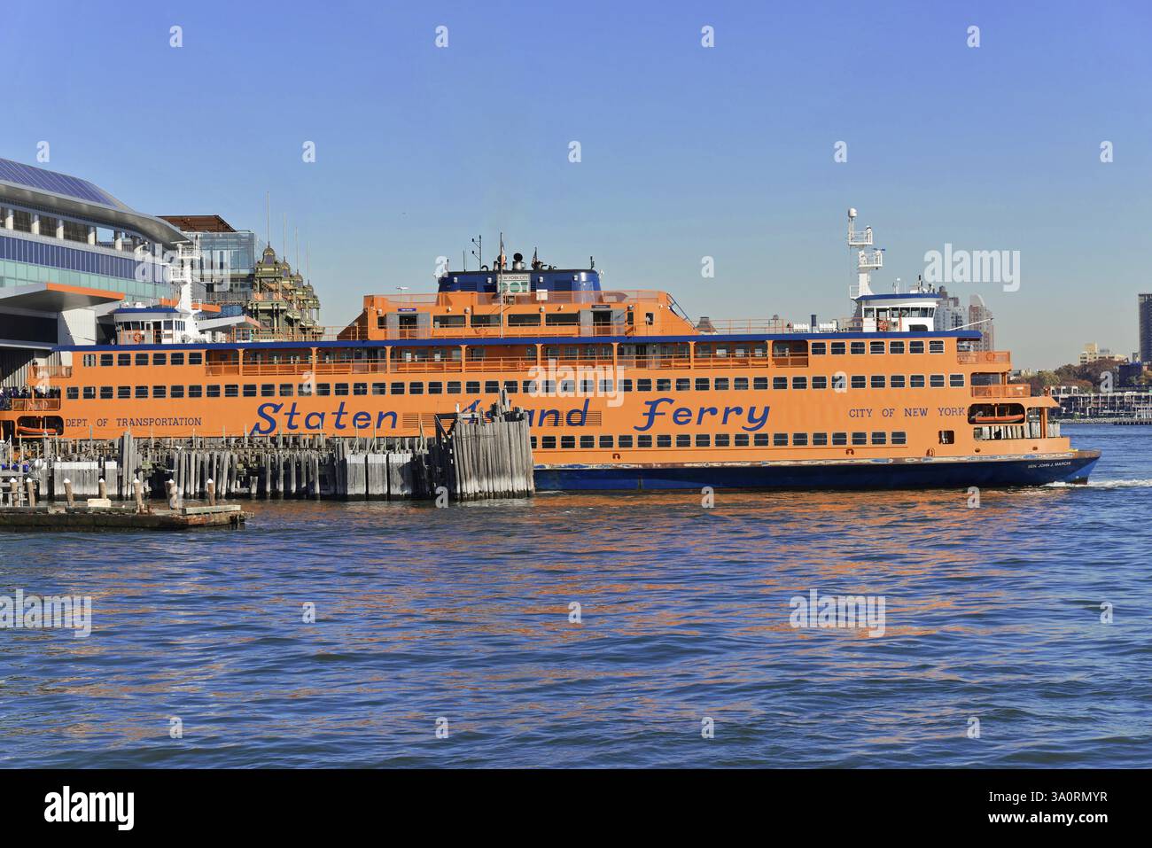 An orange-coloured Staten Island Ferry ship in the harbour, New York ...