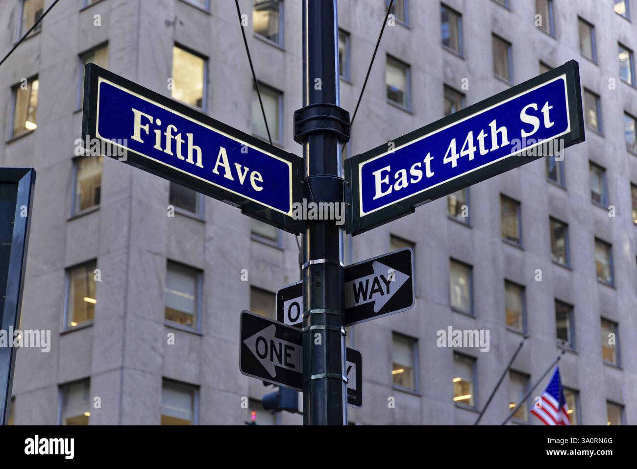 Intersection in New York with street signs in front of skyscrapers ...
