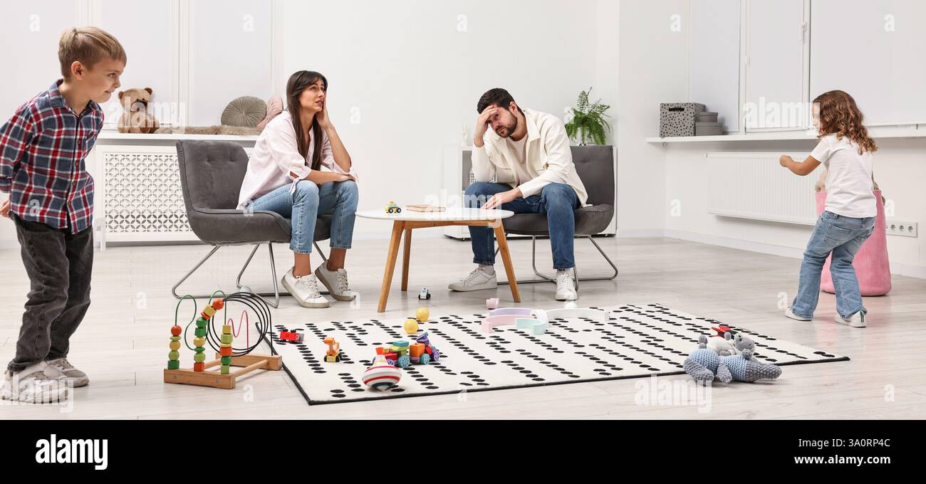 Hyperactive children playing and their overwhelmed parents at home ...