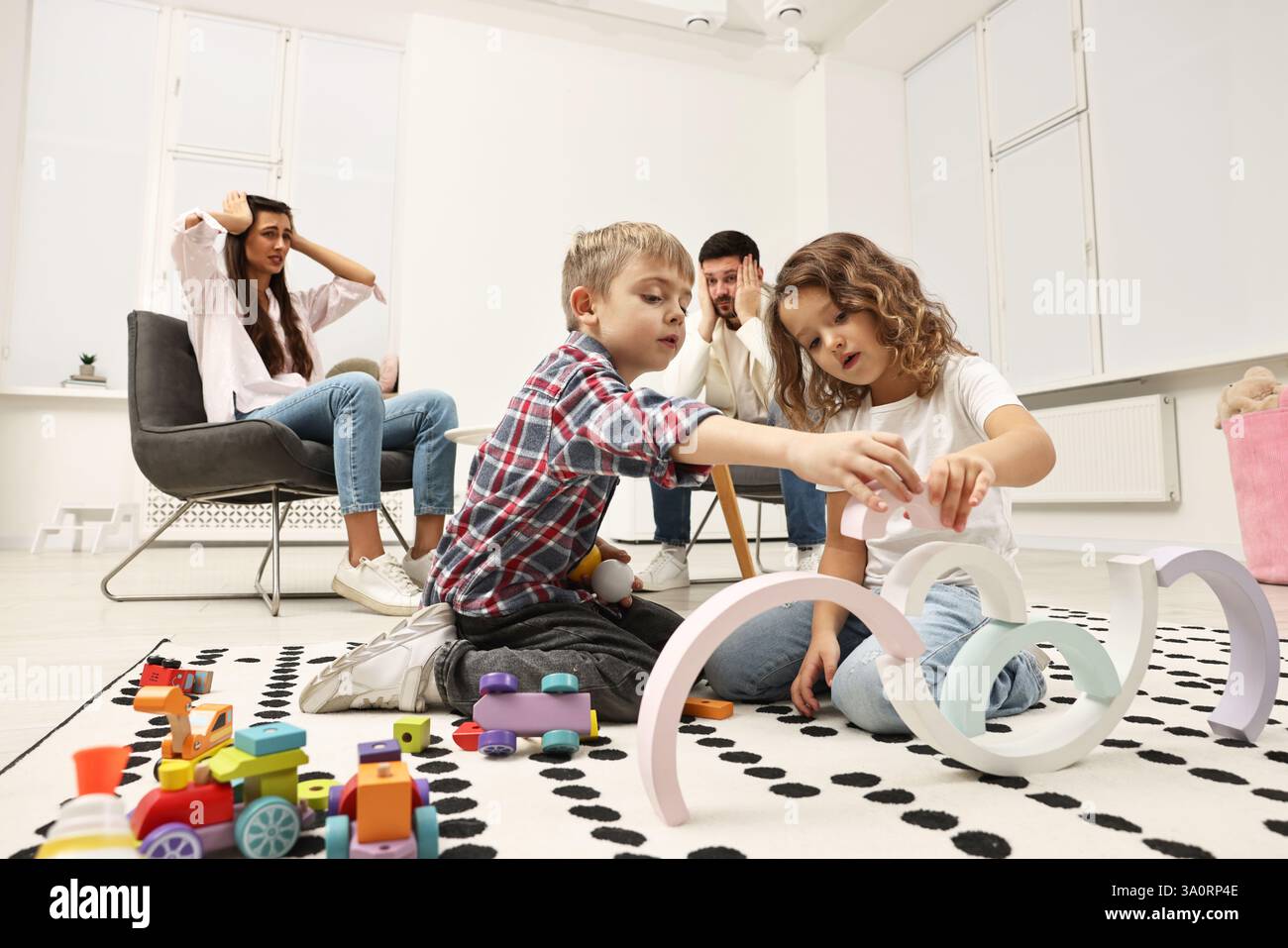 Hyperactive children playing and their overwhelmed parents at home, low ...
