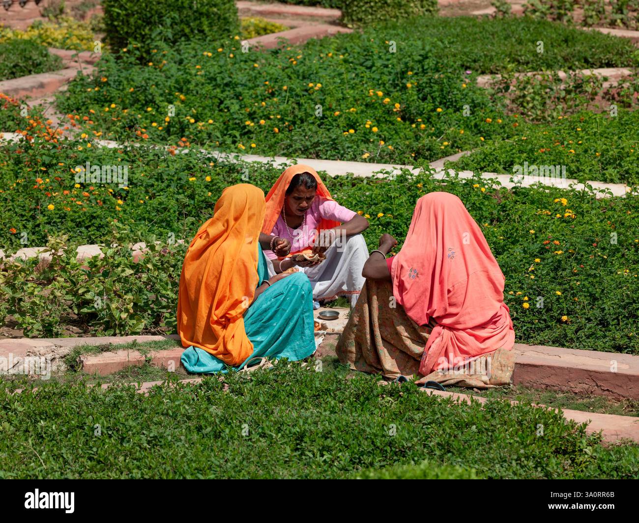 Three Indian woman enjoying a snack in the gardens of the Amber Fort in ...