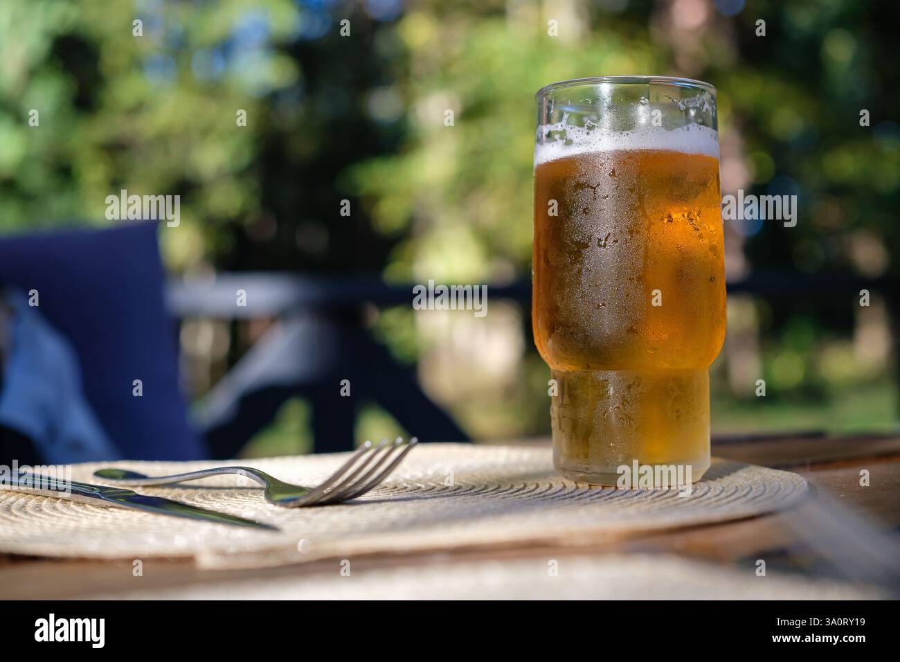 Cold beer with drops of condensation on the glass. Table setting in the ...