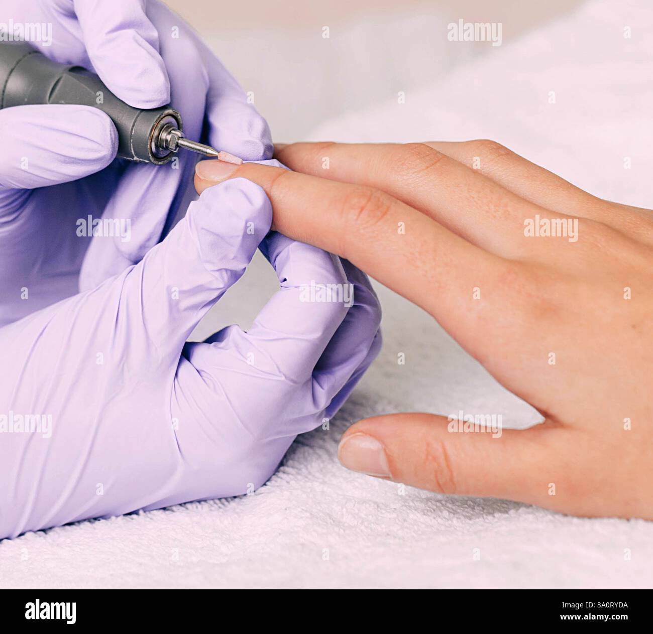 A cosmetology expert uses a rotary tool to shape and refine the client ...