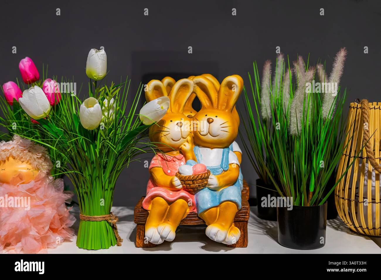 Easter bunnies figurines with basket of eggs nestled amongst an ...