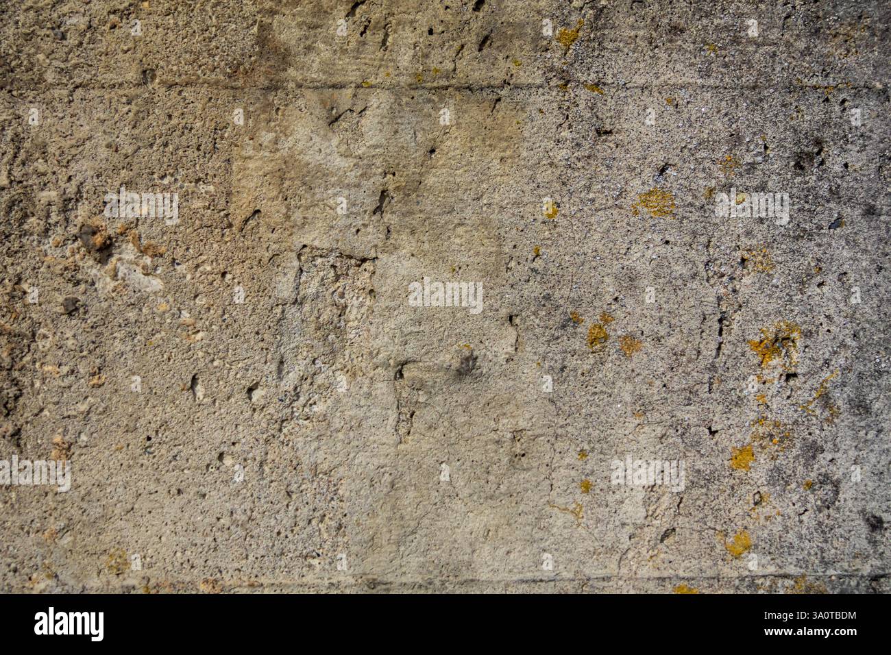 Close-up of a cement wall with rust spots, small cracks, and holes ...