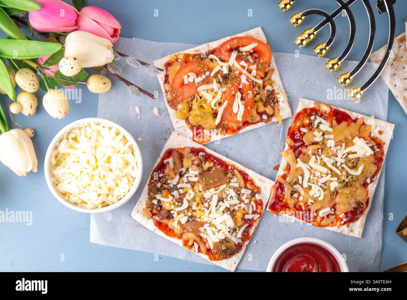 Matzah Pizza on light blue background with ingredients, cheese, tomato ...