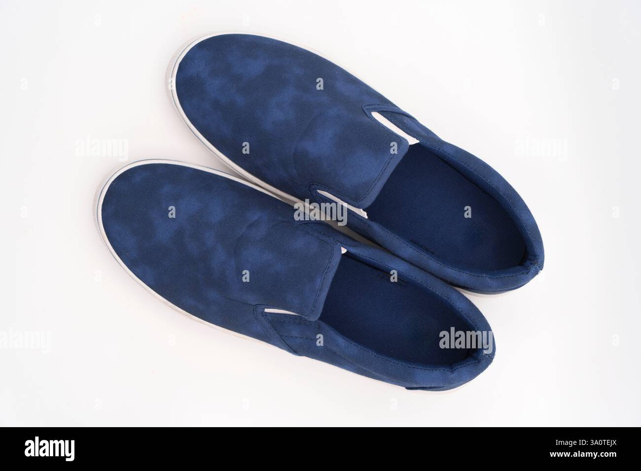 Pair of blue canvas slip-on shoes cut out isolated on white background ...