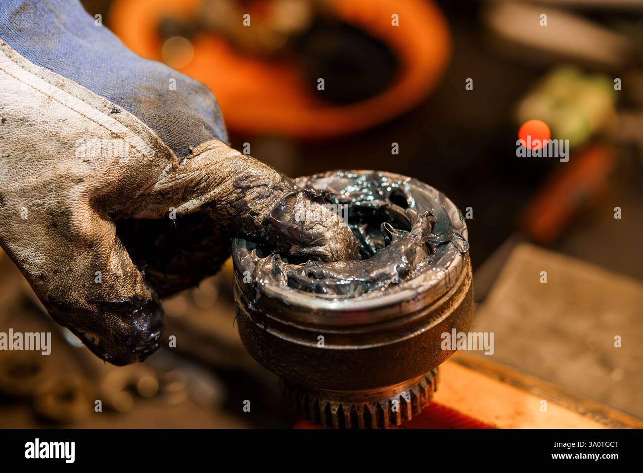 Close-Up of Gloved Hand Applying Grease to Mechanical Bearing Component ...