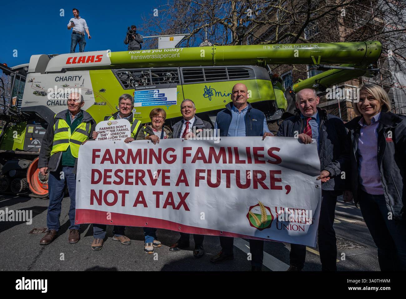 Protesters hold a banner that says "Farming families deserve a future ...