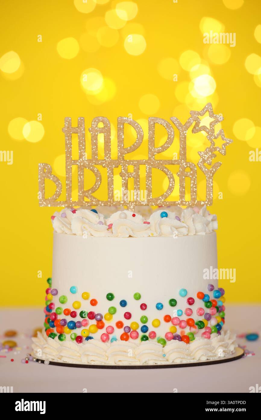 Tasty bento cake with colorful sprinkles and topper on table against ...