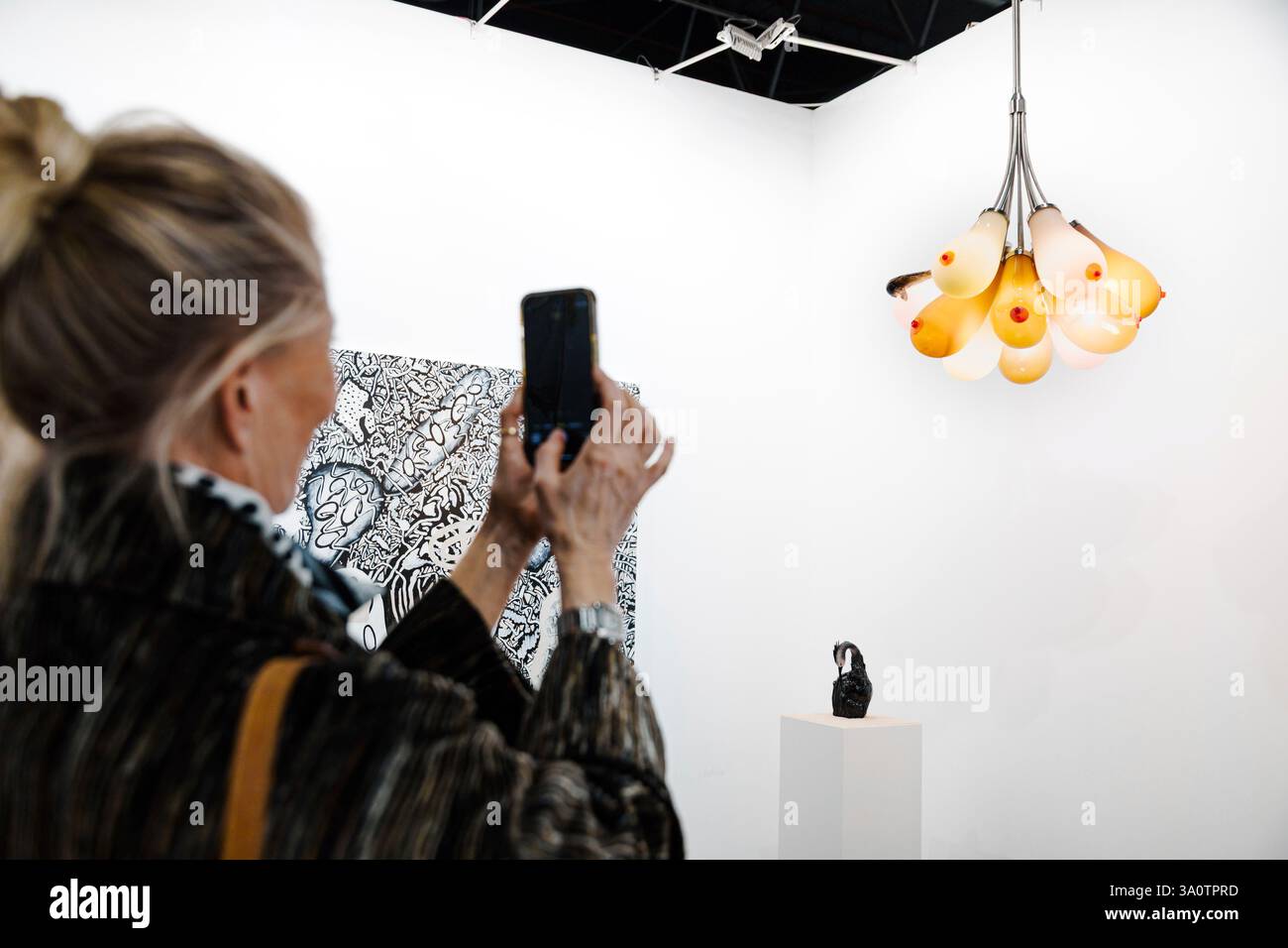 A woman photographs a work at the ARCO Madrid 2025 fair, at IFEMA ...