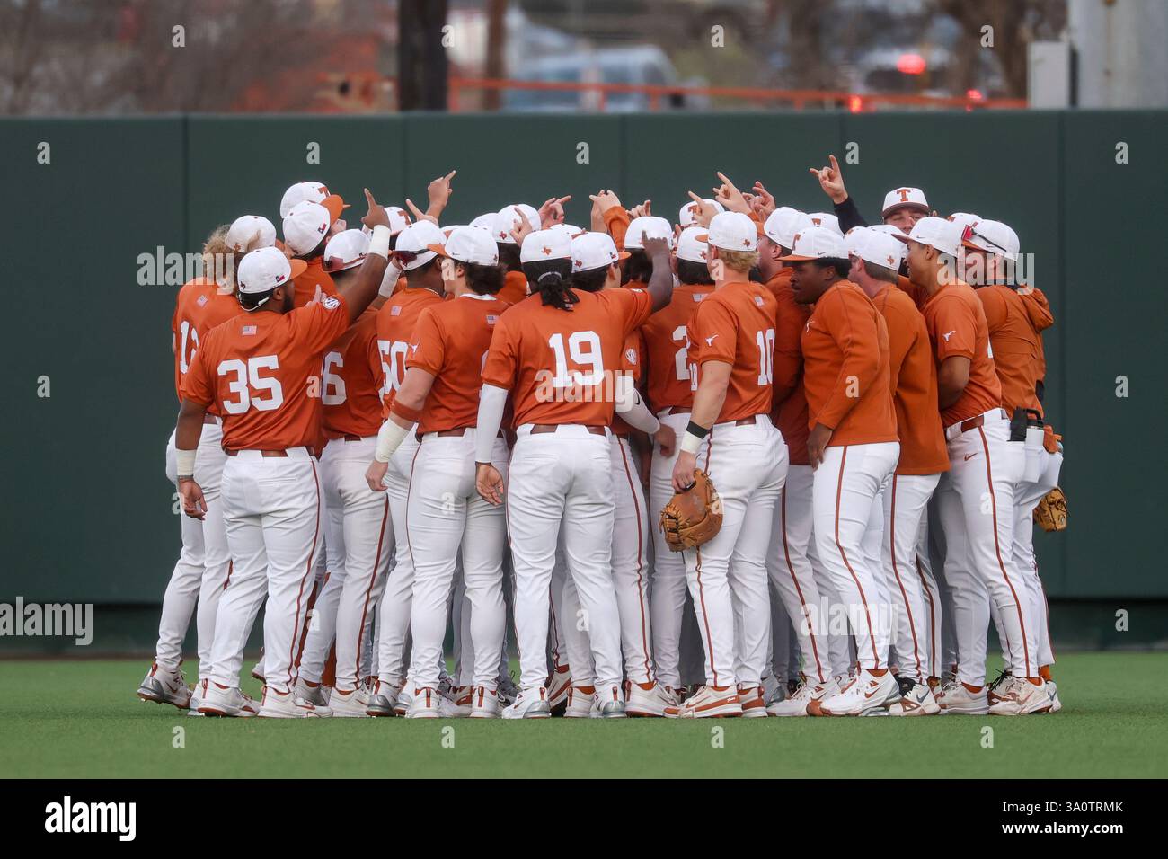 AUSTIN, TX - MARCH 04: Texas players huddle up in the outfield and hold ...