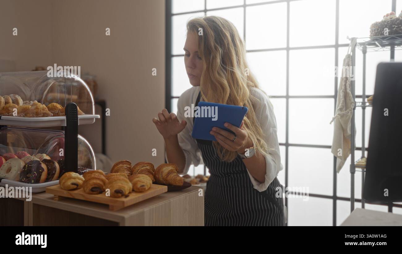 Blonde, woman, working, in, bakery, holding, tablet, near, pastries ...