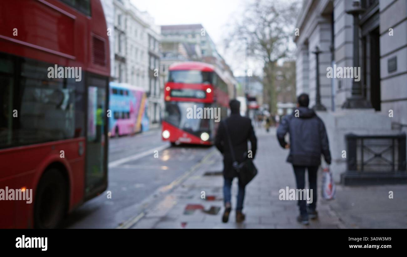 Blurred cityscape captures men walking alongside iconic london double ...